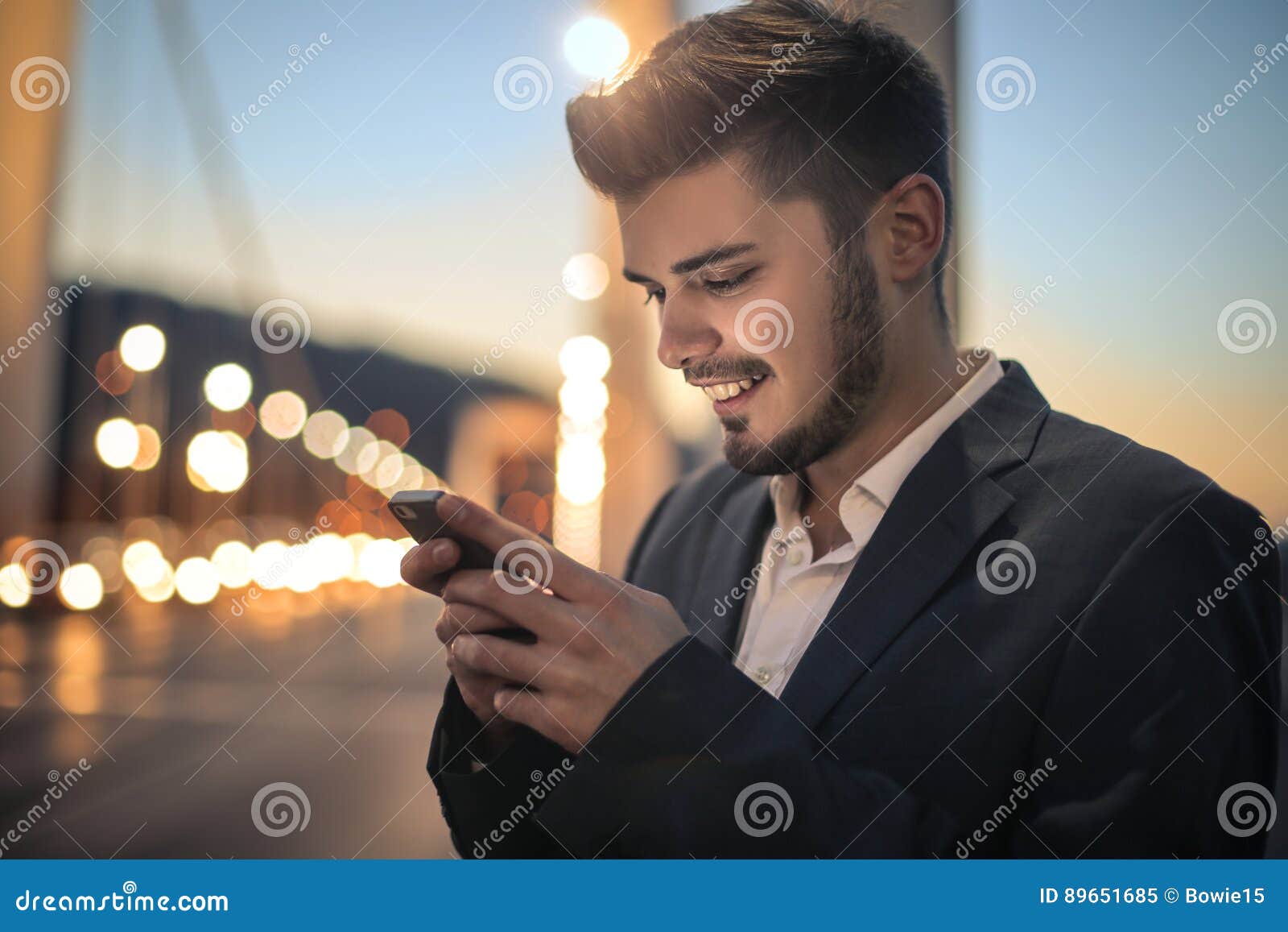Man smiling at his phone stock image. Image of city, happy - 89651685