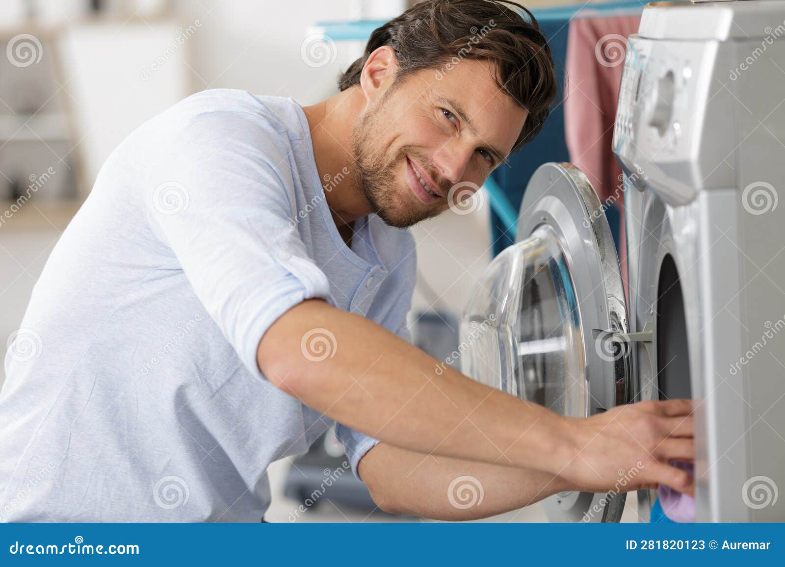 Man Smiling while Loading Washing Machine Stock Image - Image of happy ...