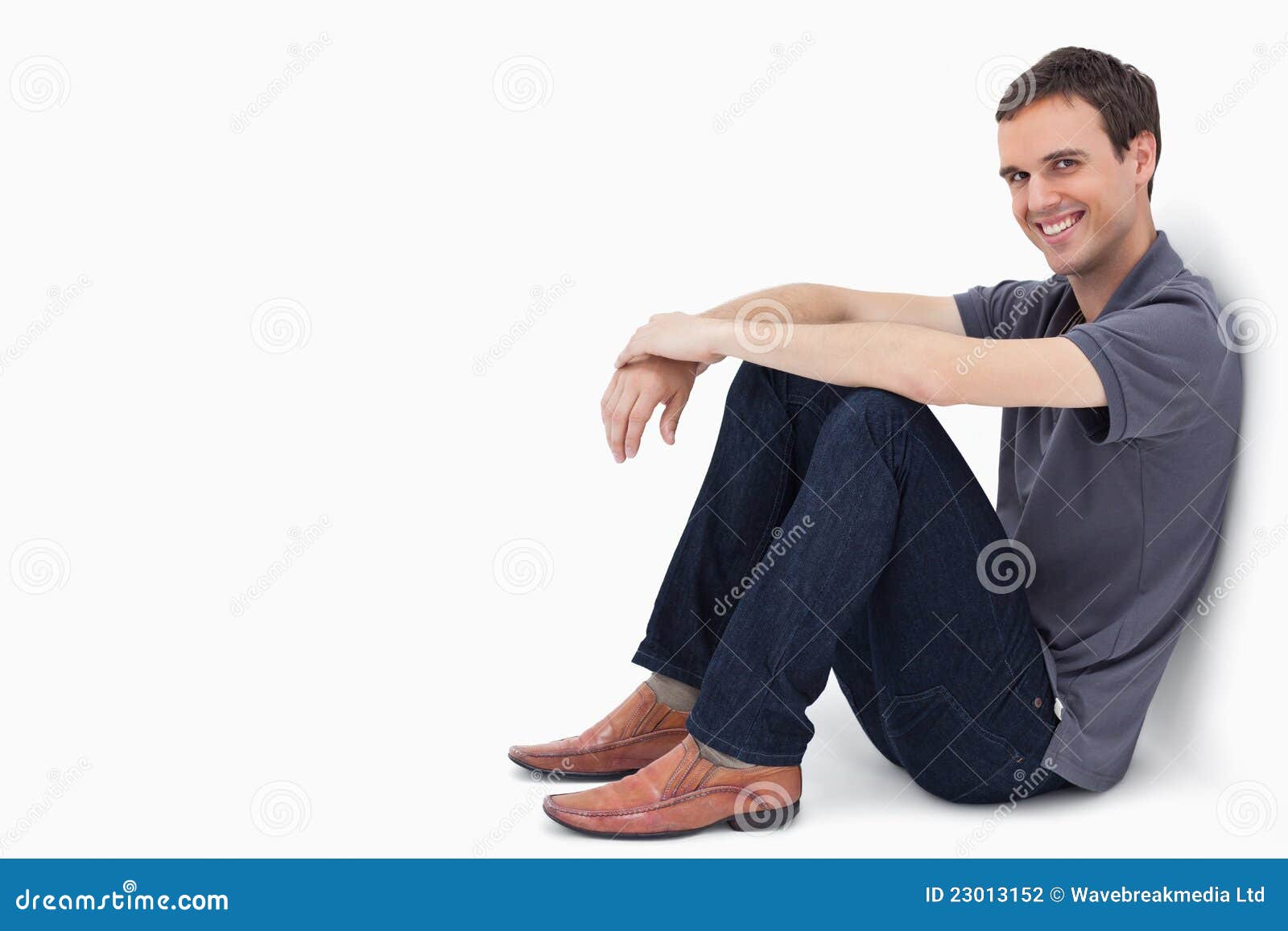 A Man Smiling while Sitting Against a Wall Stock Photo - Image of ...