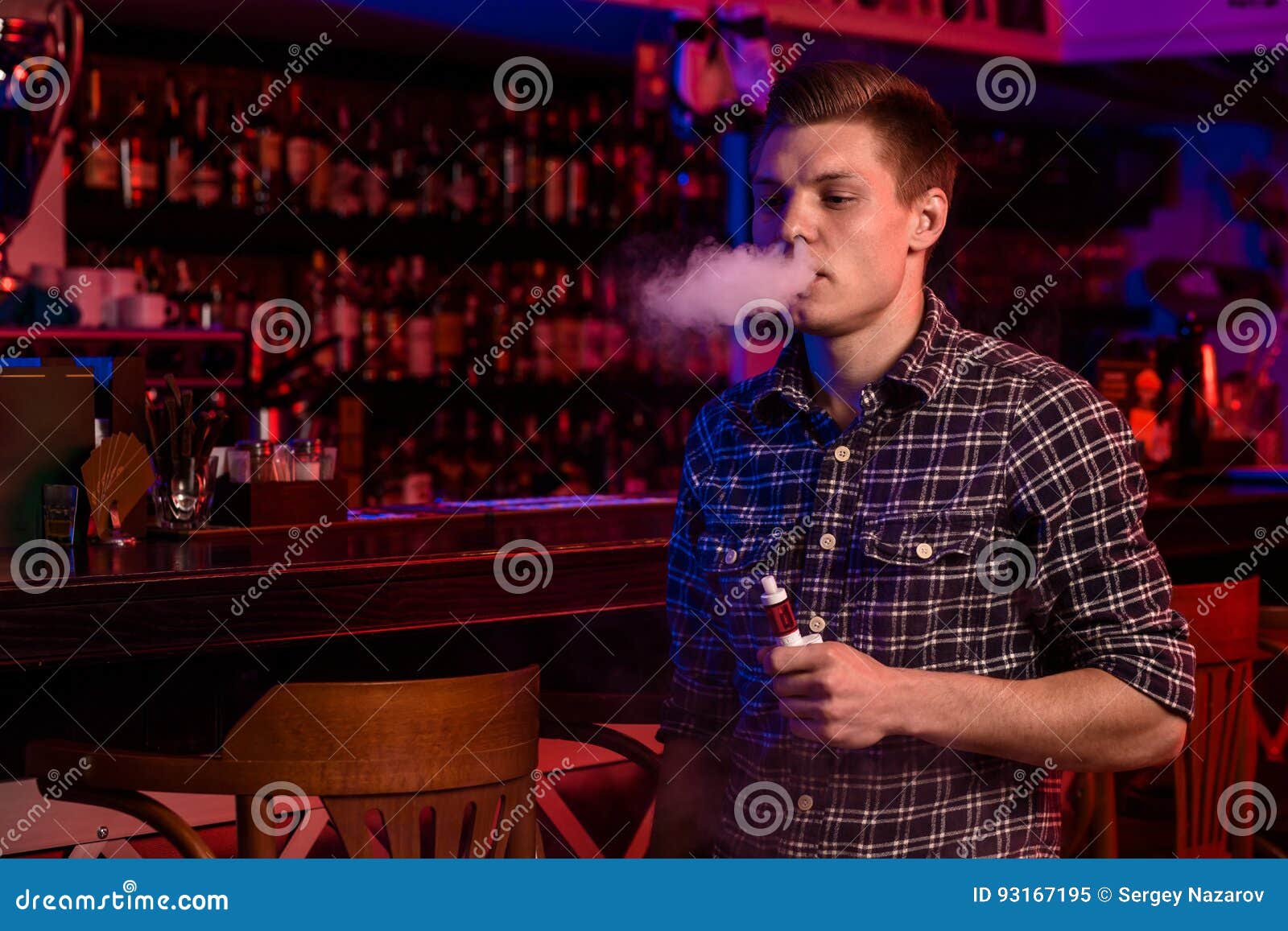 The Man Smoke an Electronic Cigarette at the Vape Shop. Stock Image ...