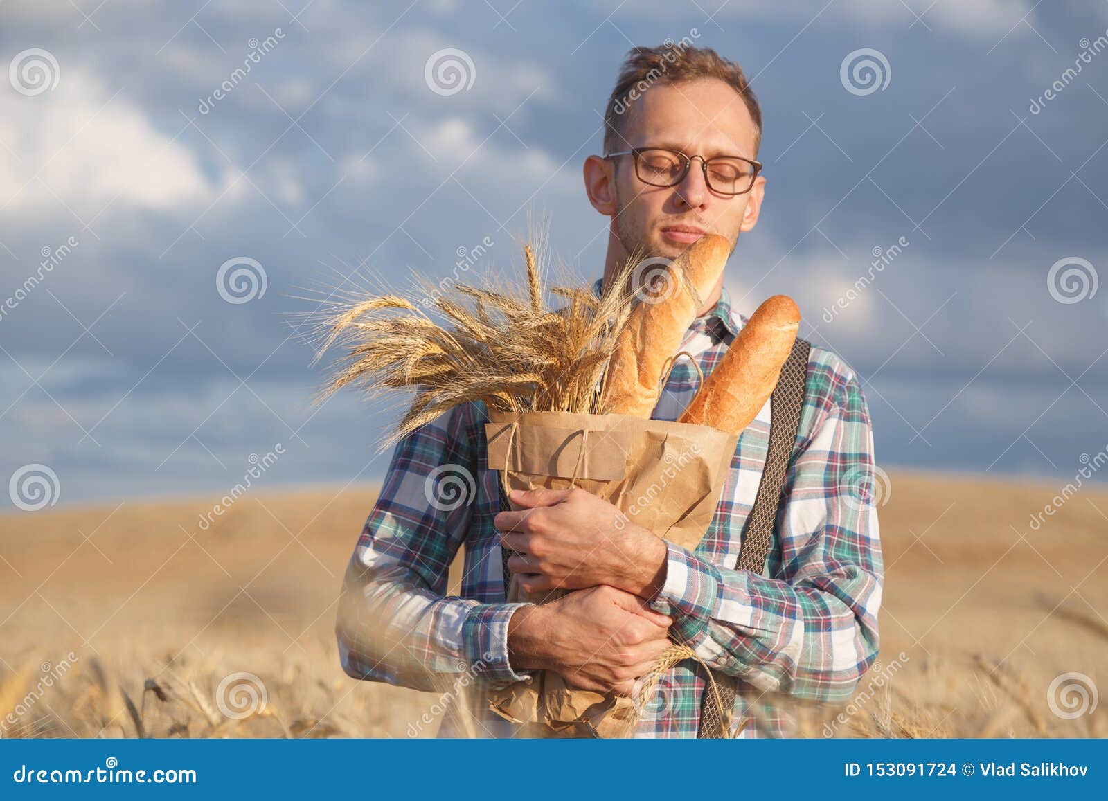 A Man is Sniffing Fresh Bread Standing in a Rye Field Stock Photo ...