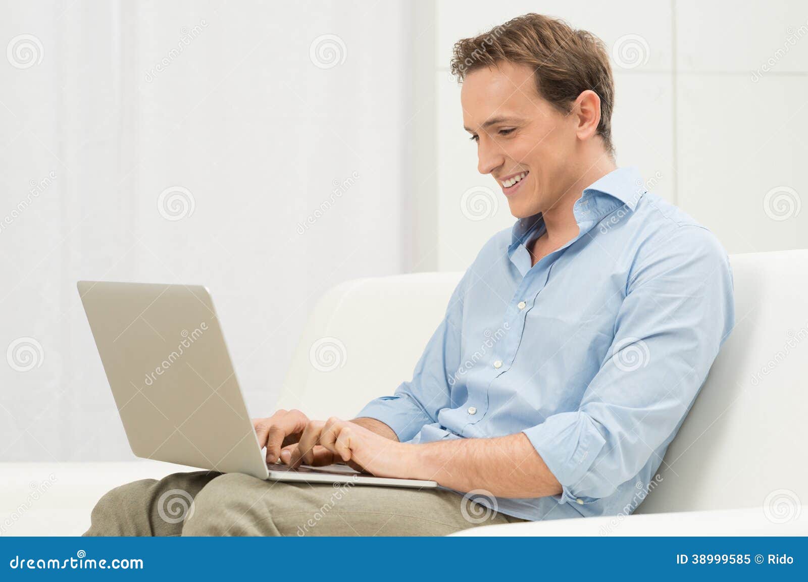 Man on Sofa with a Laptop stock image. Image of communication - 38999585