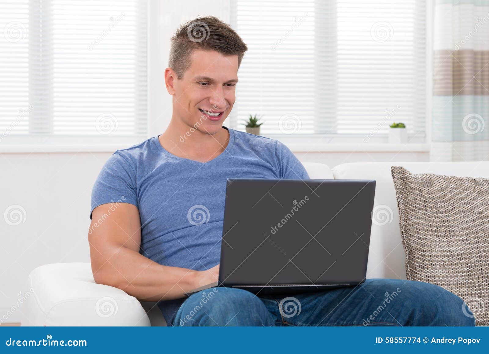 Man on Sofa Using Laptop stock photo. Image of people - 58557774