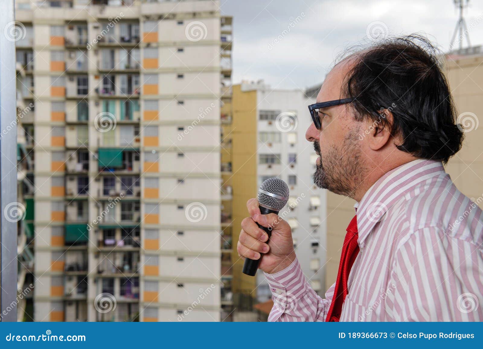 Man Speaking into Microphone Stock Image - Image of city, people: 189366673