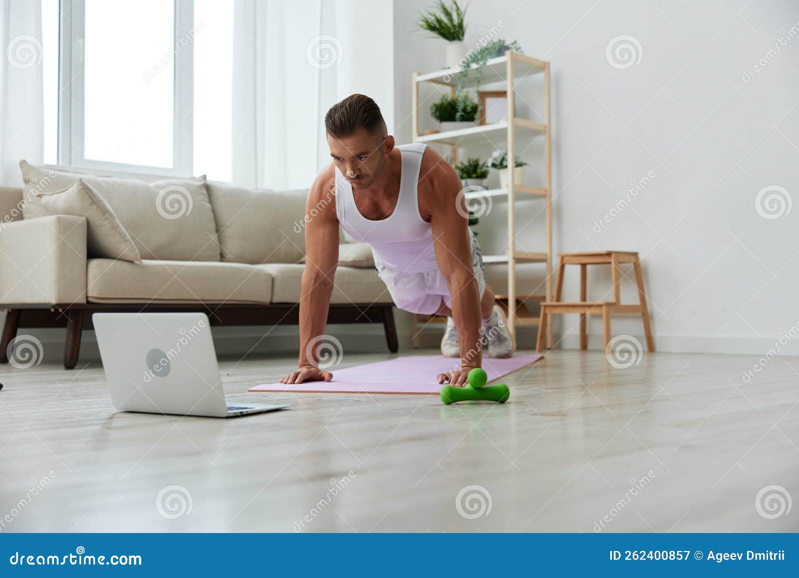 Man Sports Watching Tape Of Workout On Phone And Repeating Exercises