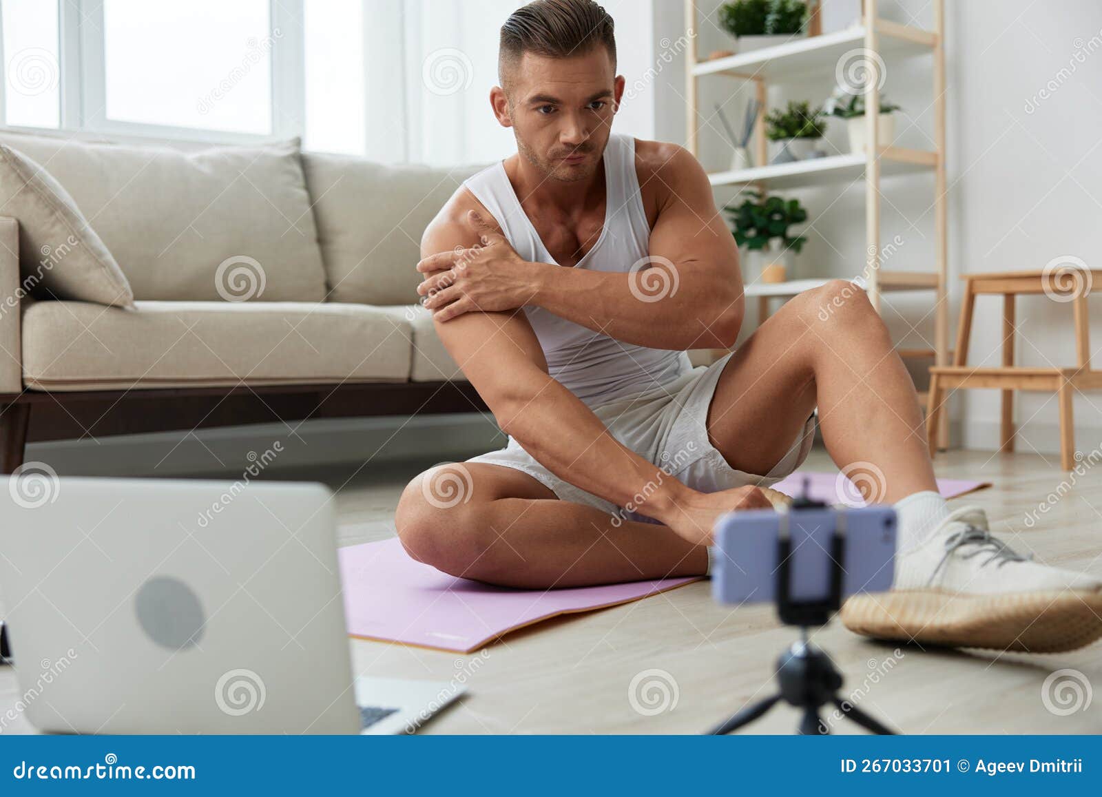 Man Sports Watching Tape Of Workout On Phone And Repeating Exercises