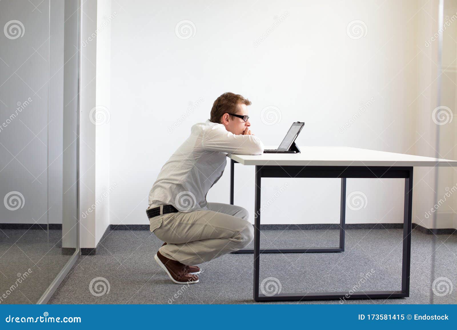 Man Squatting at the Desk, Working with Tablet Stock Image - Image of ...