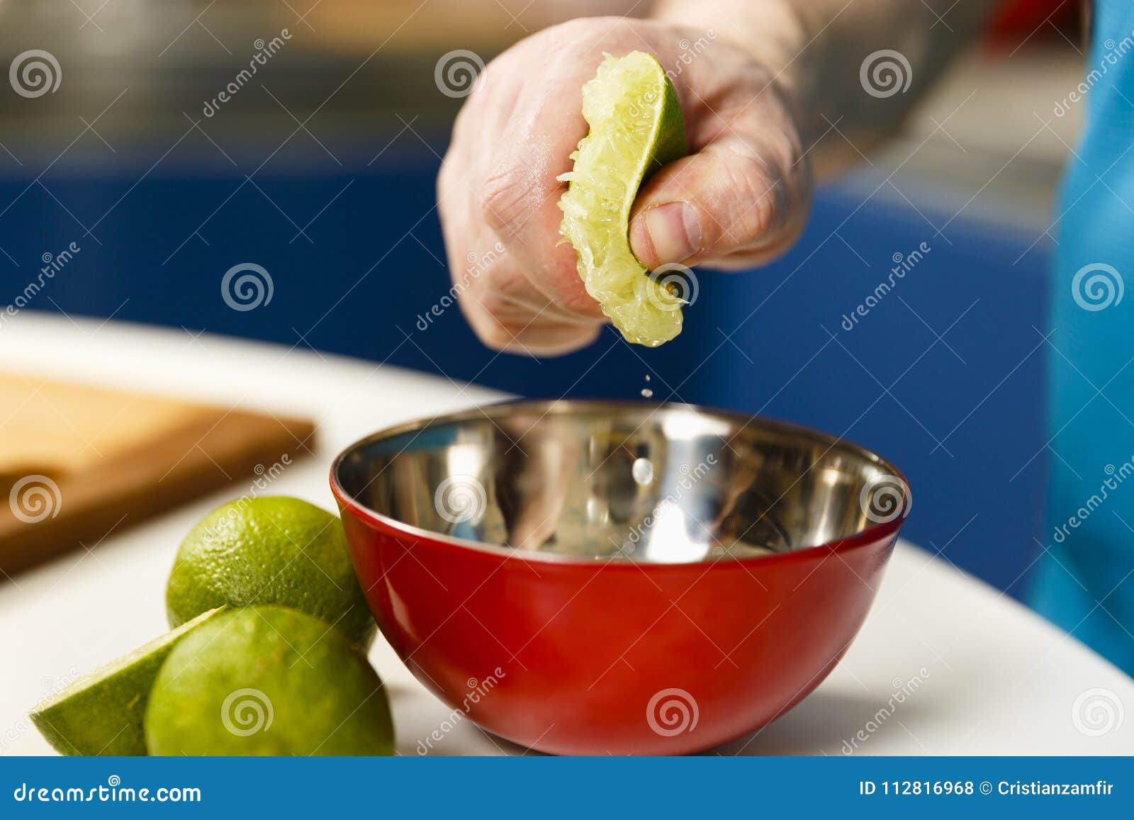 Man Squeezing Half a Lime into a Bowl Stock Photo - Image of cooking ...