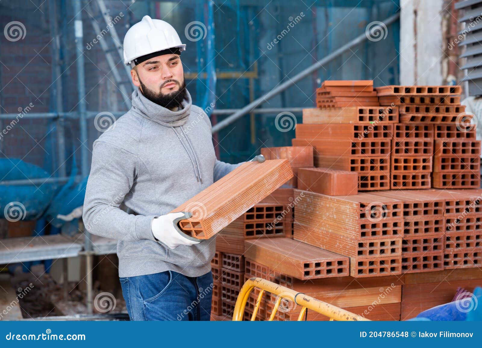 Man stacking red bricks stock photo. Image of positive - 204786548