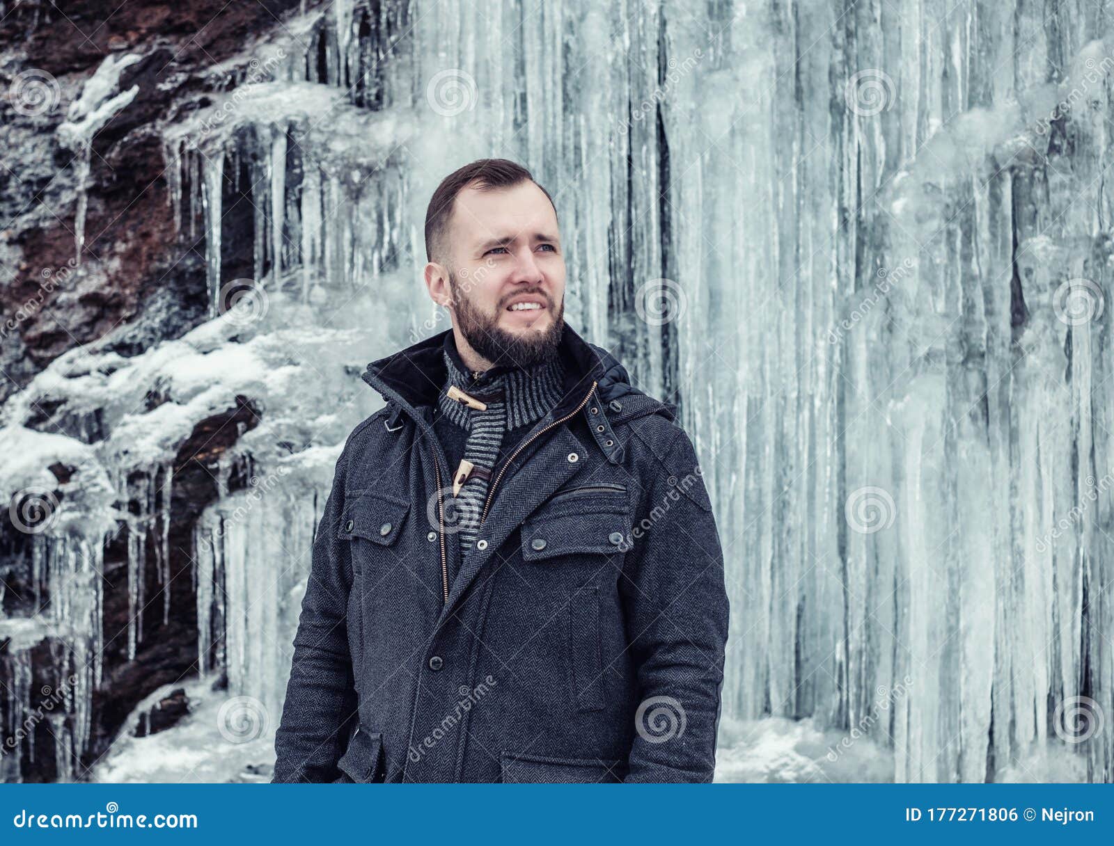 Man Standing Against Cliff Full of Icicles Stock Photo - Image of ...