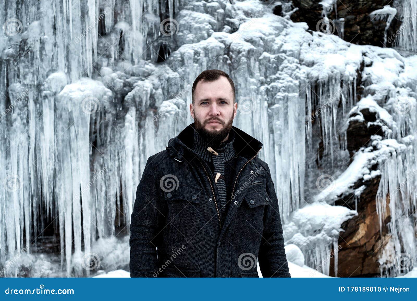 Man Standing Against Cliff Full Of Icicles Stock Photo - Image of ...