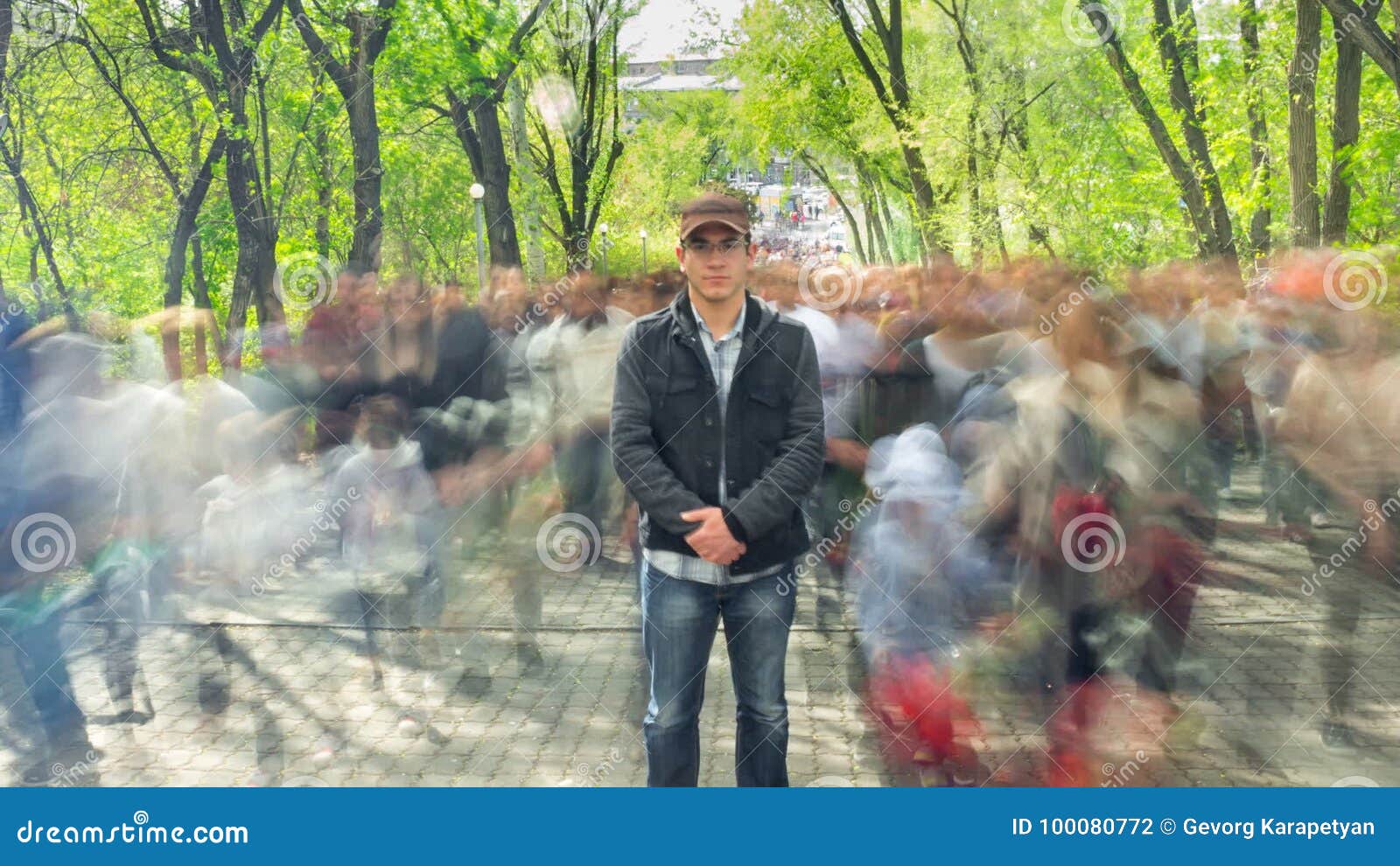 Man Standing Alone in Blurred Crowd, on Background Green Trees. the ...