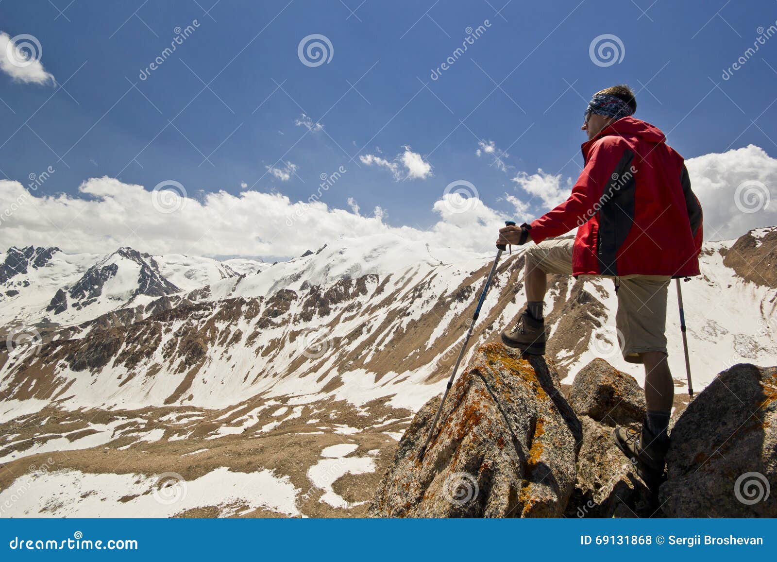 Man Standing on a Cliff in Mountains with Poles Stock Photo - Image of ...