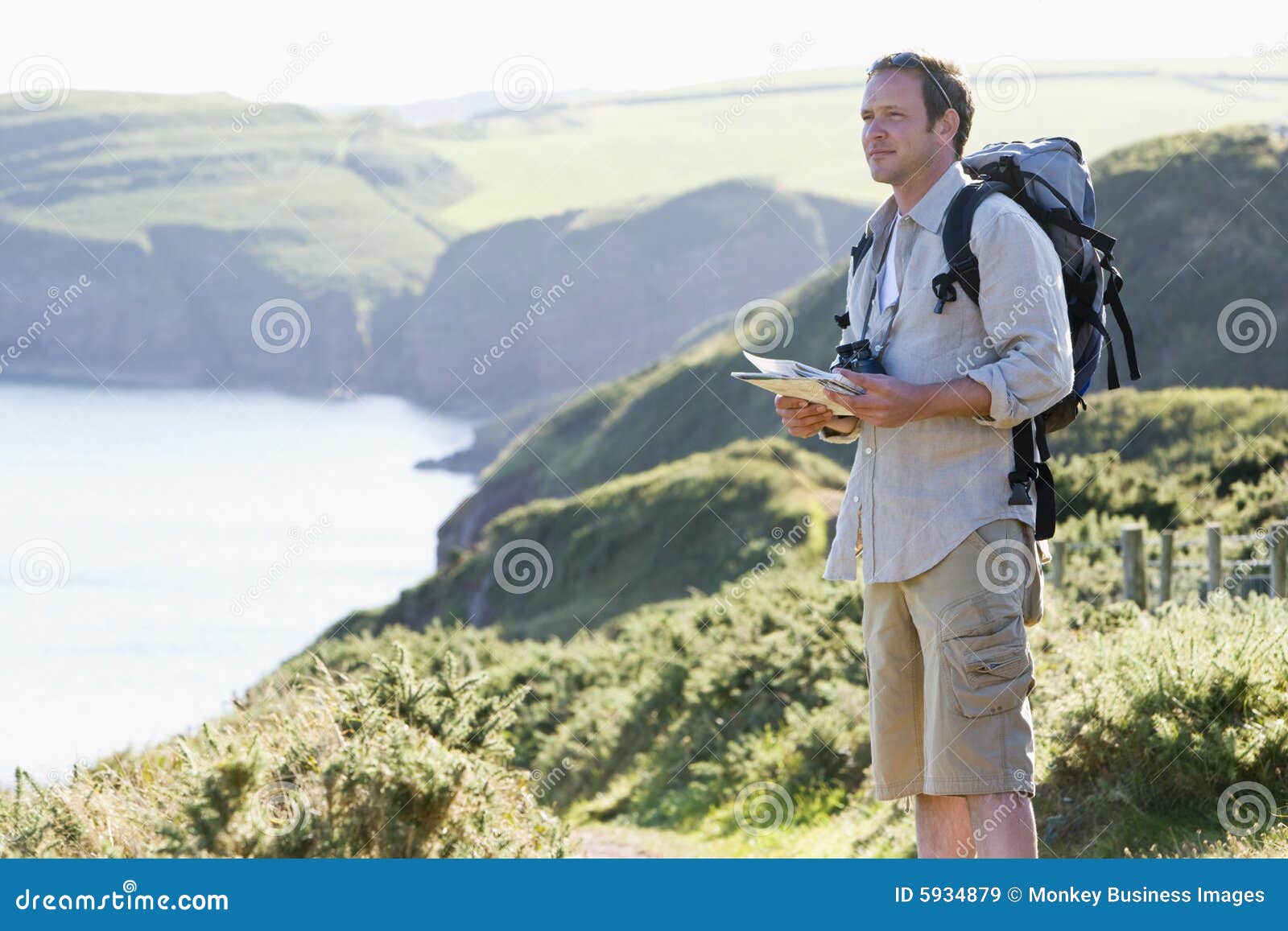Man Standing on Cliff Side Path Holding Map Stock Image - Image of ...