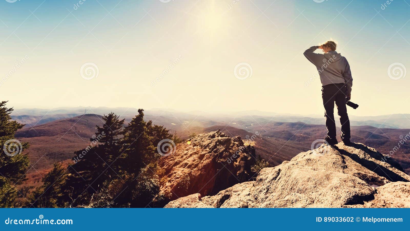 Man Standing on a Cliffs Edge Overlooking the Mountains Below Stock ...