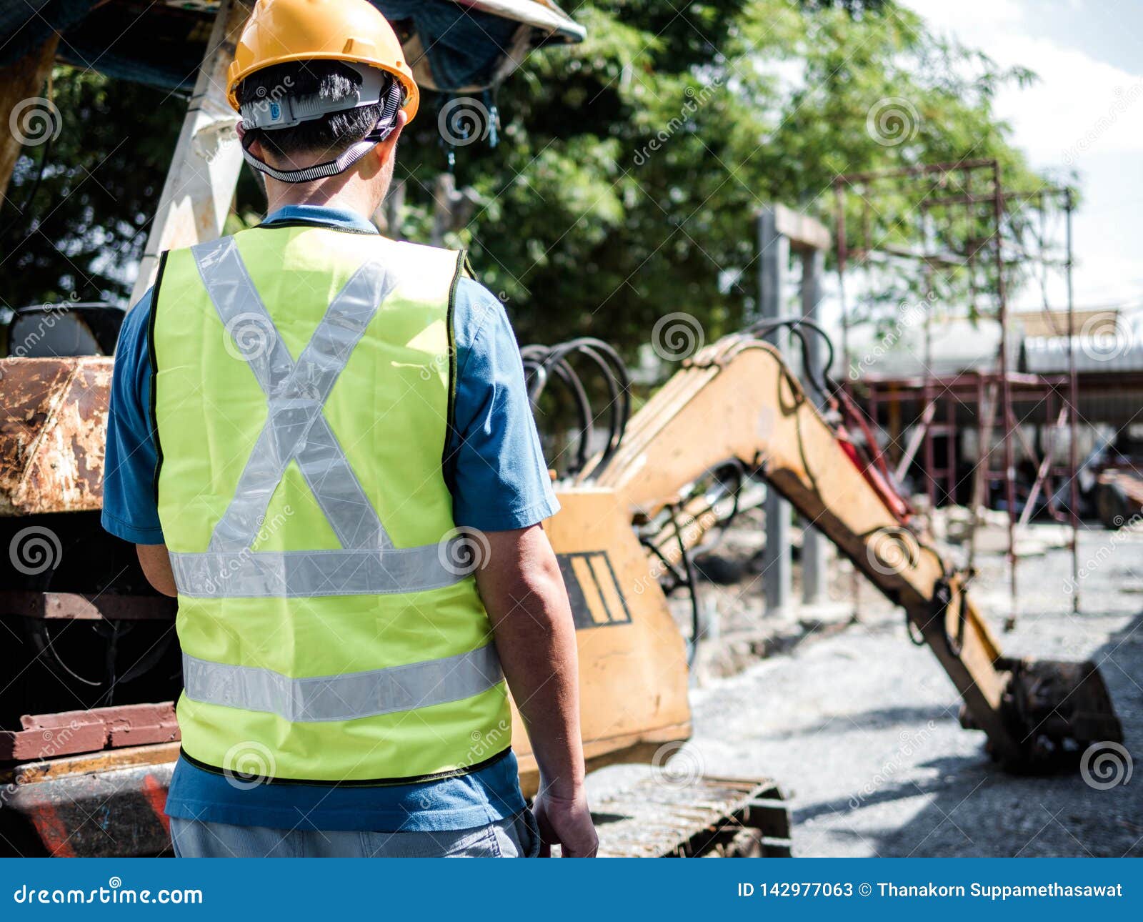 Man Standing In A Construction Site With Digger Loading Trucks ...