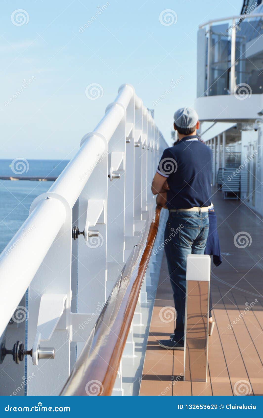 A Man Standing on the Deck of a Cruise Ship and Looking at the Shore on ...