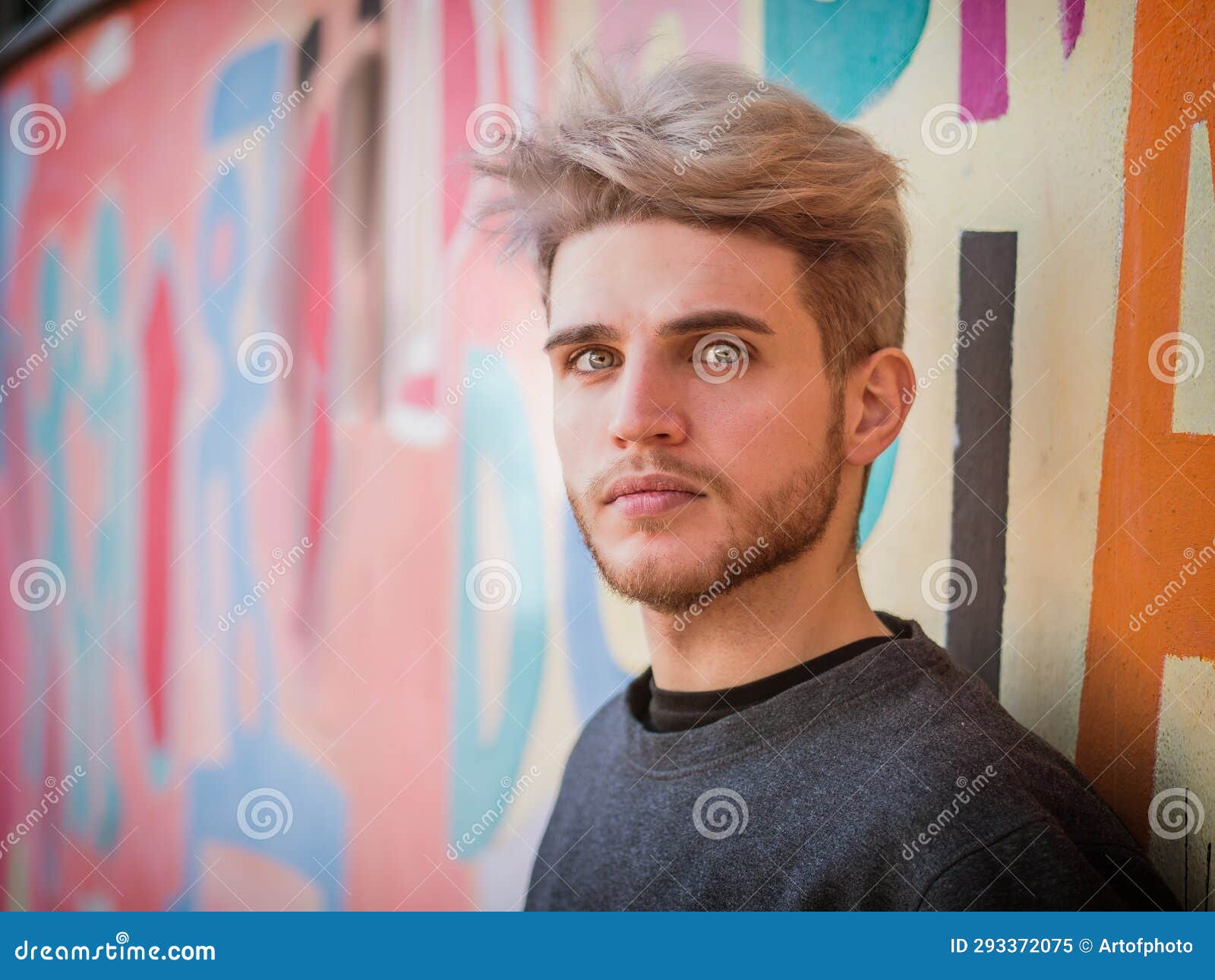 Photo of a Man Standing in Front of a Vibrant and Colorful Wall Stock ...