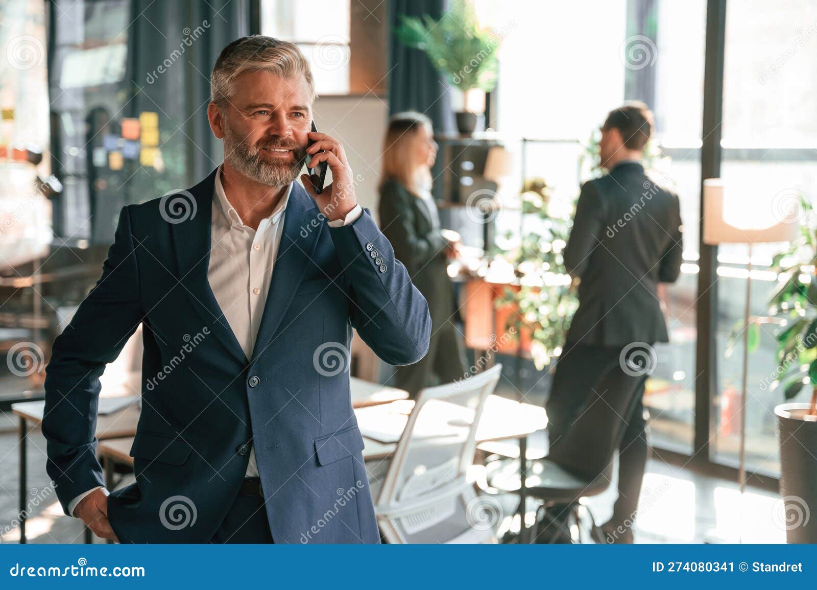 Man is Standing and Having Phone Call. Group of Business People are ...