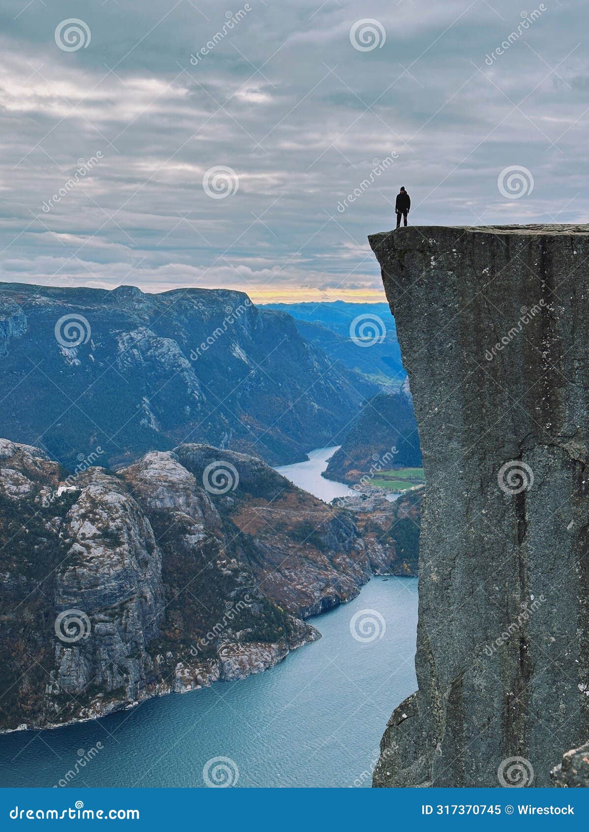 A Man on the Top of a High Cliff Overlooking a Lake Stock Image - Image ...