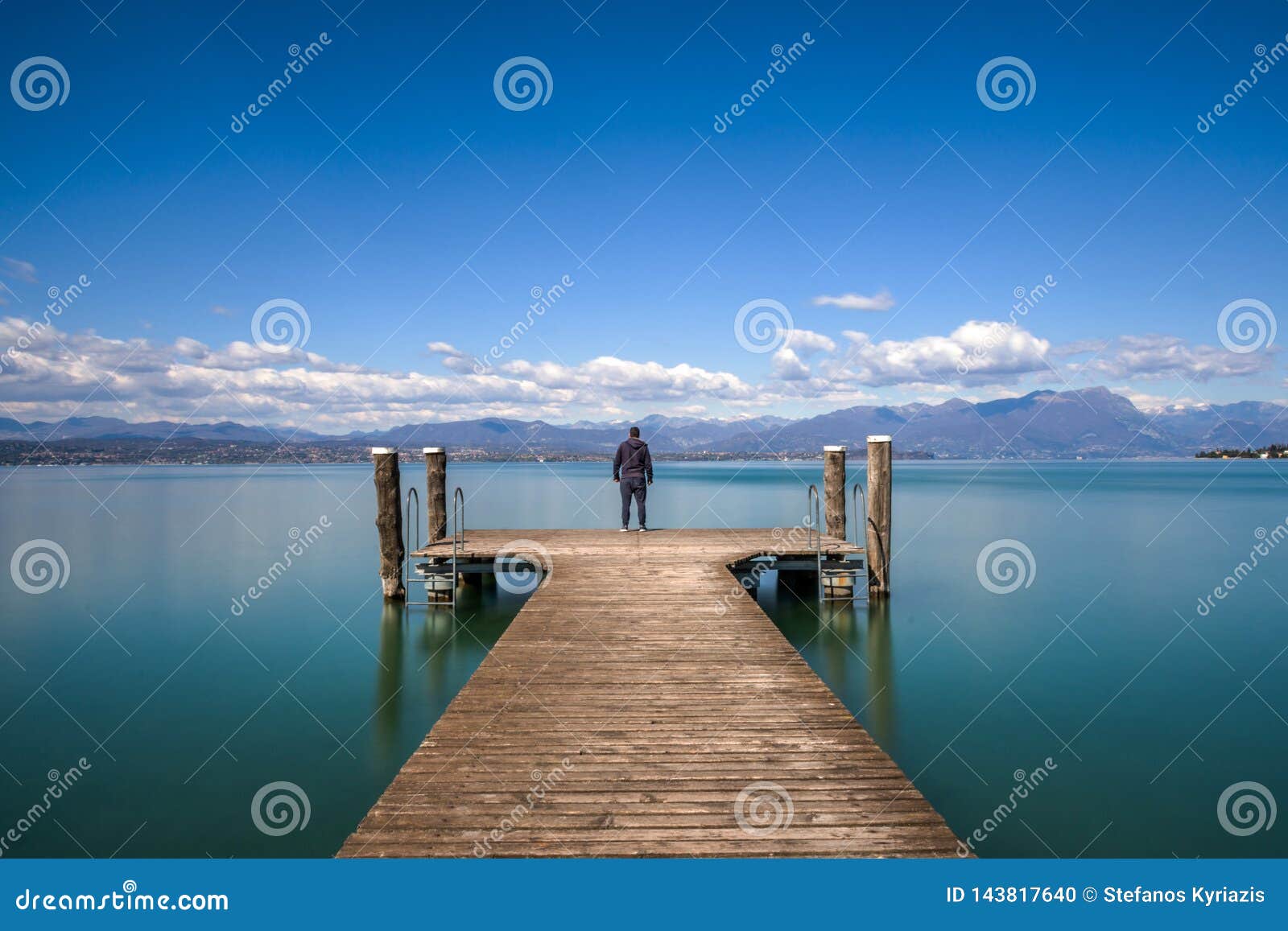 Man Standing on a Jetty by Tranquil Lake Stock Photo - Image of ...