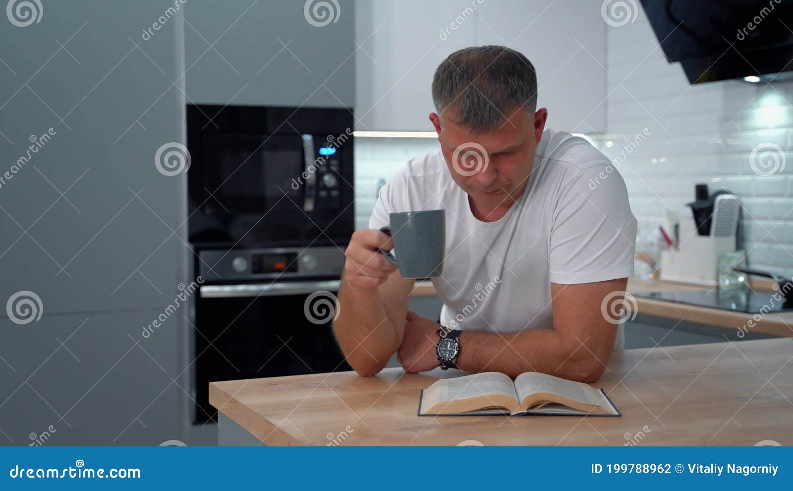 A Man Standing in the Kitchen Reading a Book Stock Footage - Video of ...