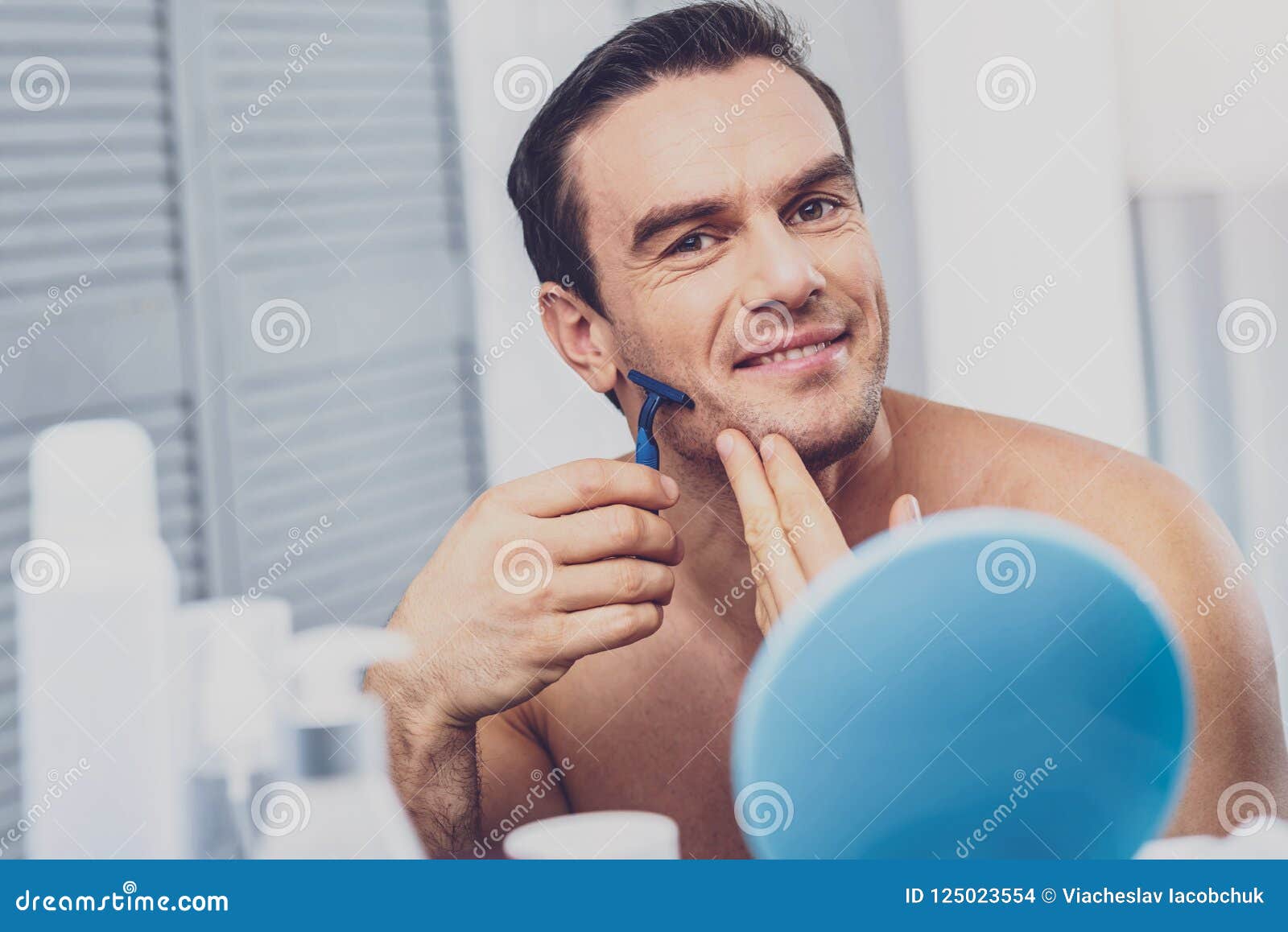 Man Standing in Light Bathroom in Front of Mirror Stock Photo - Image ...