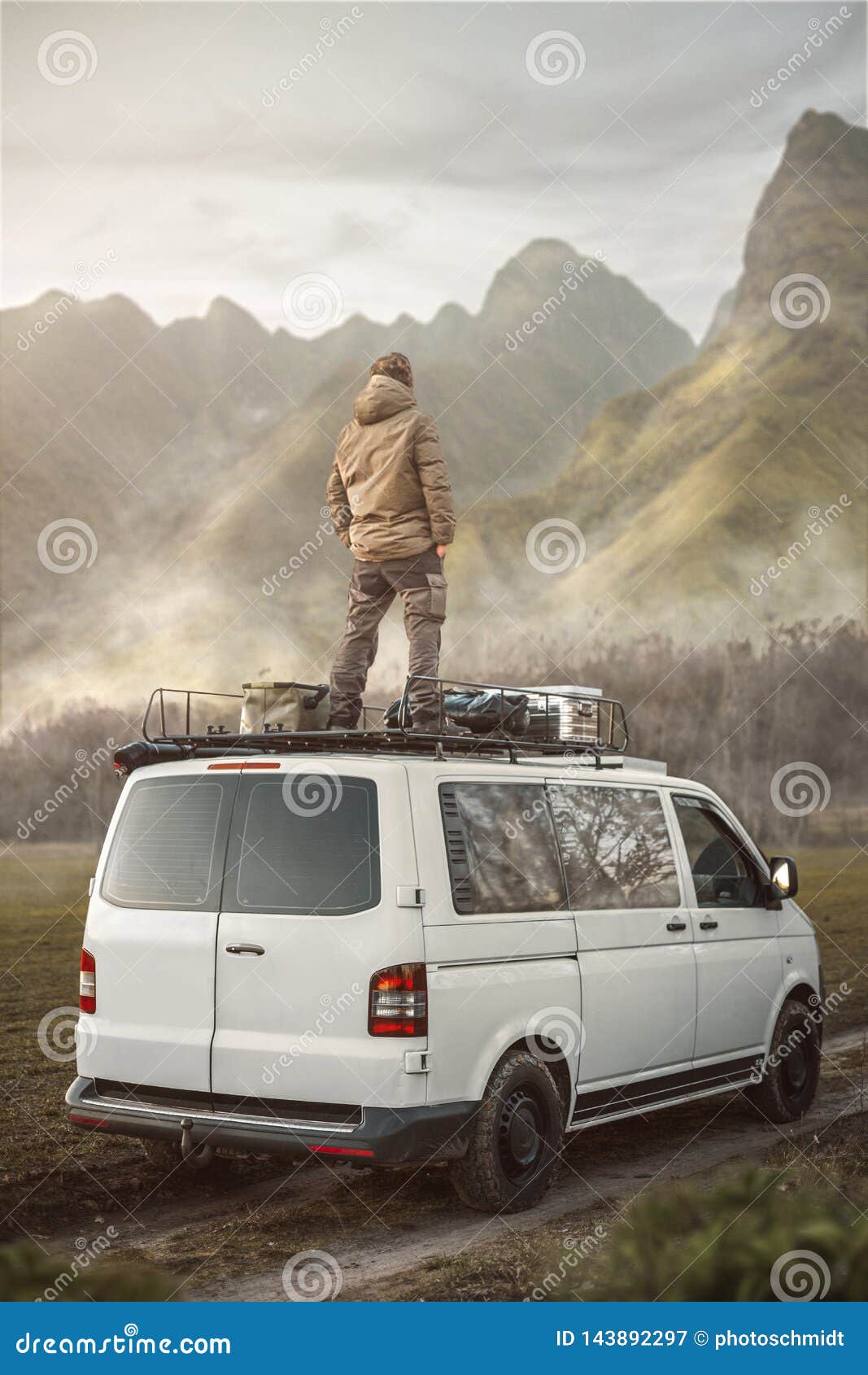 Man Standing on the Roof of a Van Surrounded by Mountains and Nature ...