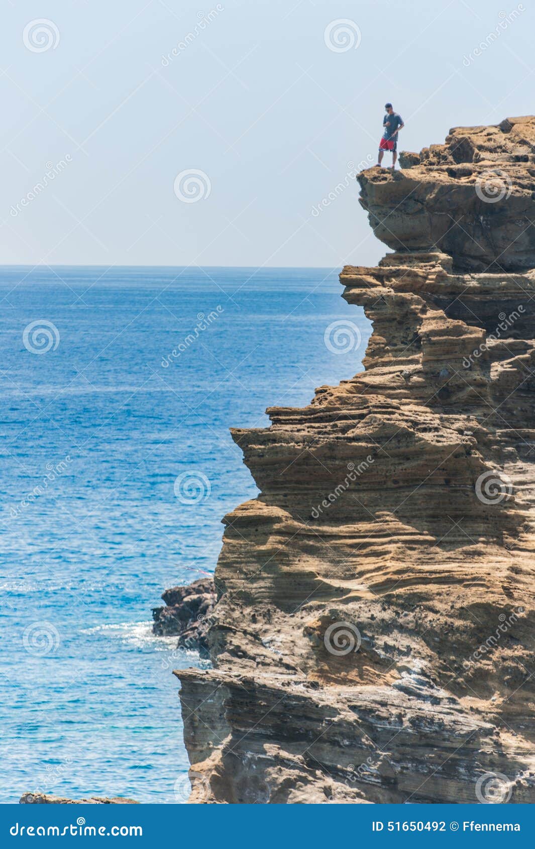 Man Stands on Cliff Above Ocean Stock Photo - Image of tourism, water ...