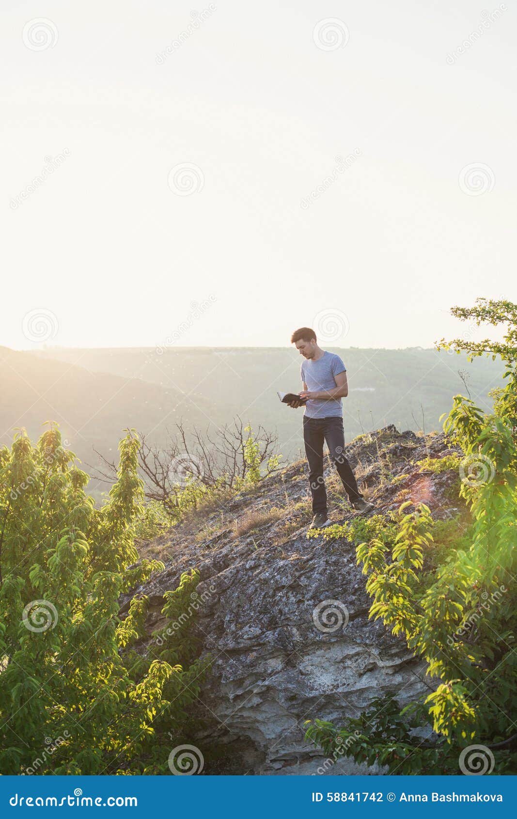 Man Stands on a Hill and Reading a Book Vertical Stock Photo - Image of ...
