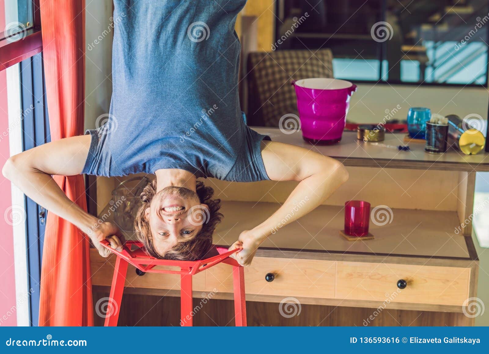 A Man Stands on His Hands Upside Down in the Kitchen Stock Photo ...