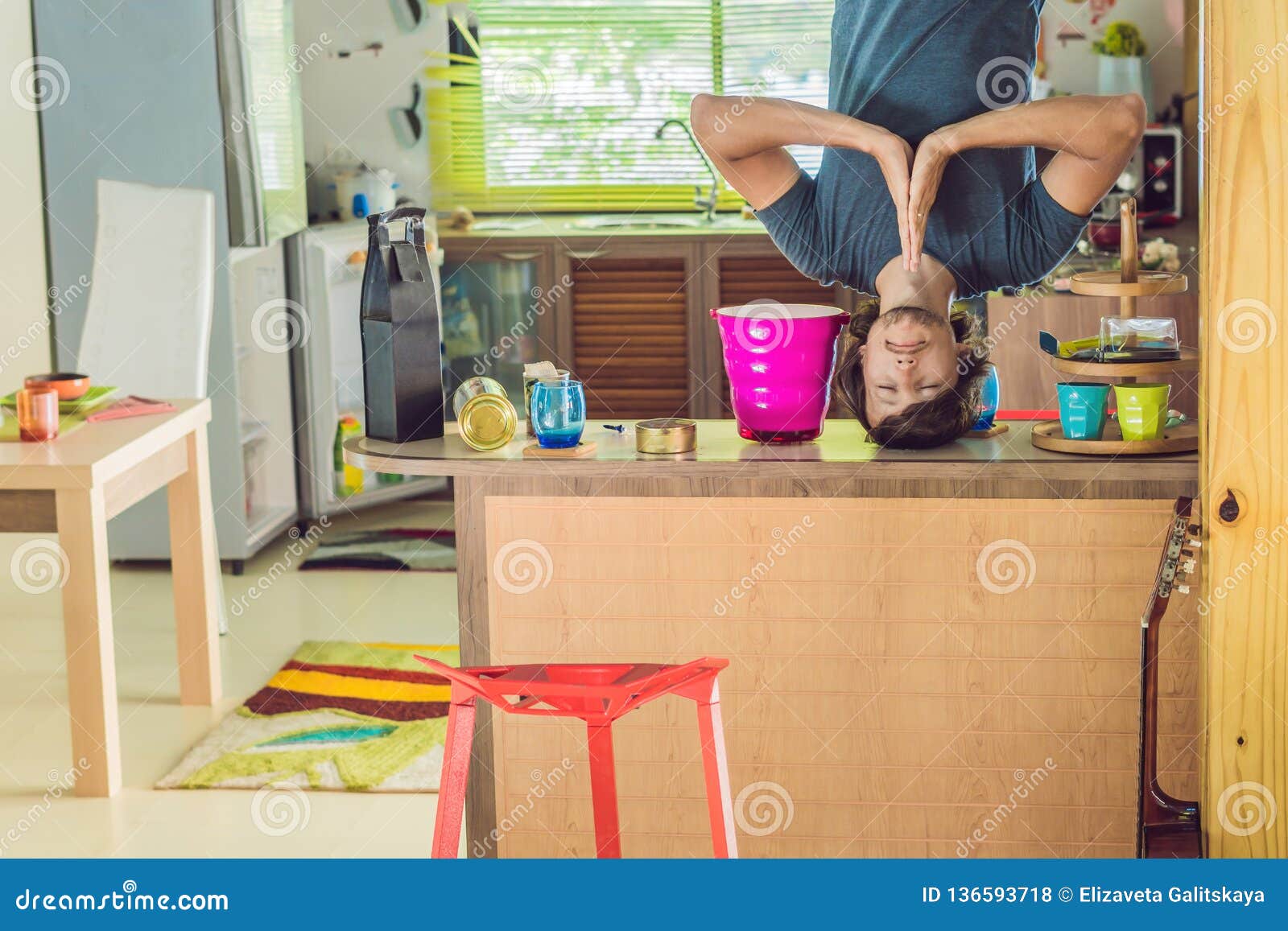 A Man Stands on His Hands Upside Down in the Kitchen Stock Photo ...