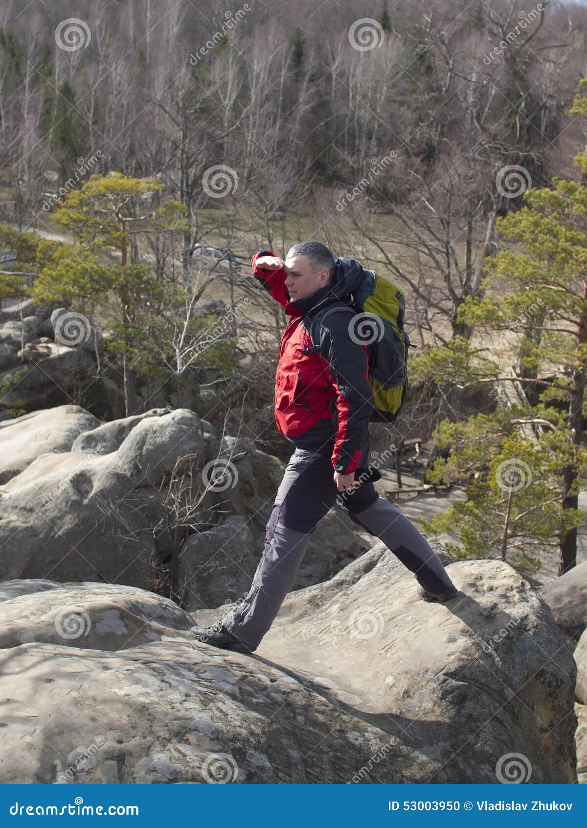 A Man Stands on a Mountain and Looking into the Distance. Stock Photo ...