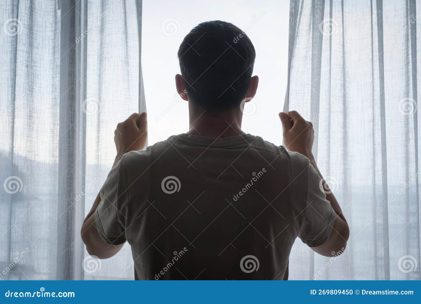 Man Stands at Window and Opens Curtains Back View. Stock Photo - Image ...