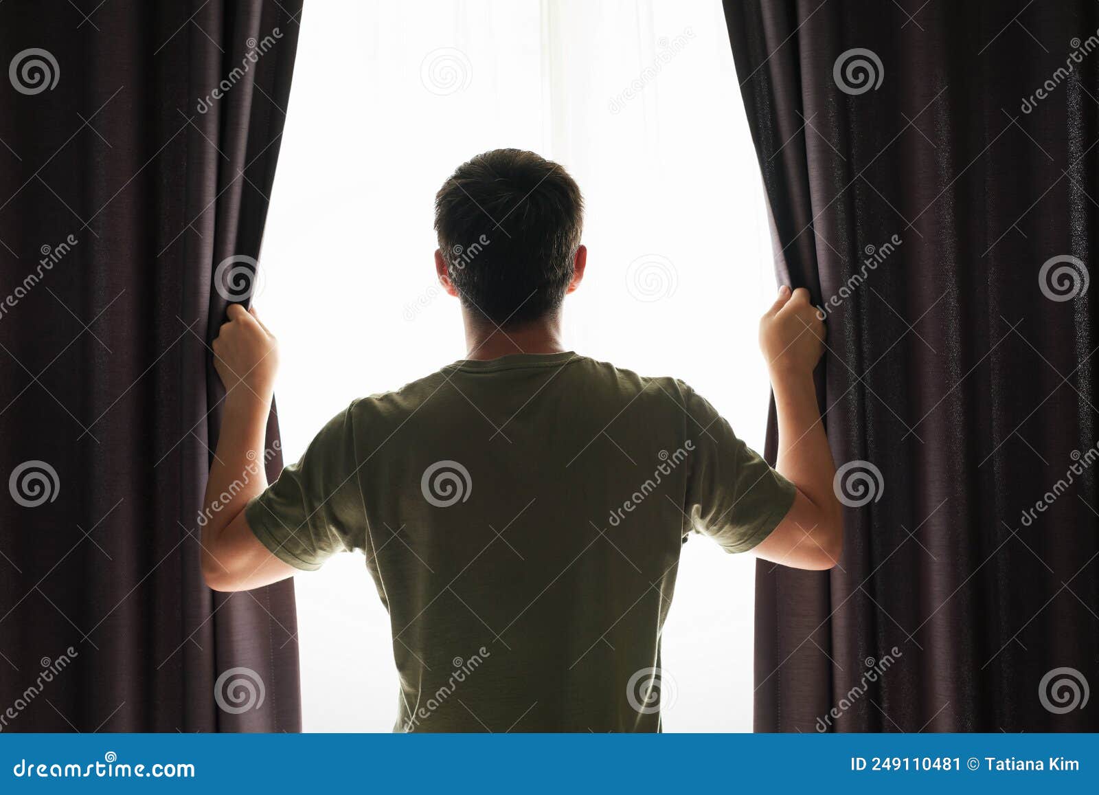 Man Stands at the Window and Opens Curtains Back View. Stock Image ...