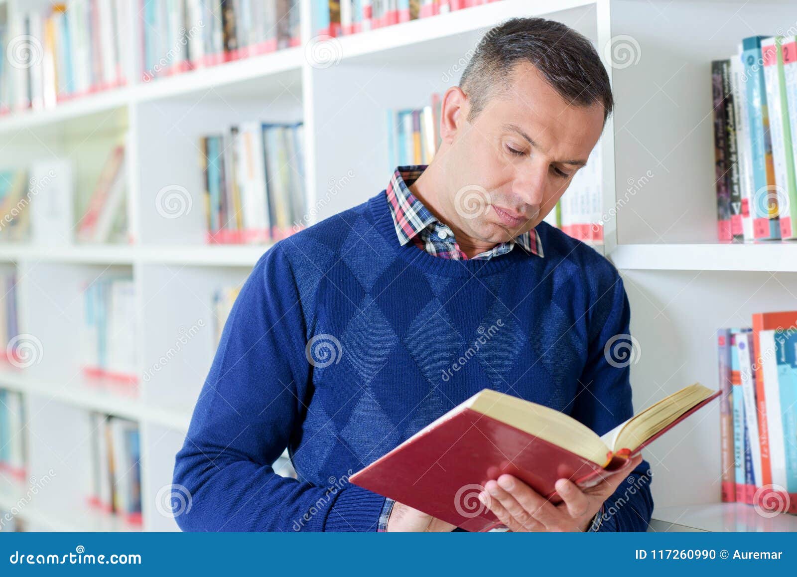 Man Stood Looking at Book in Library Stock Photo - Image of repository ...