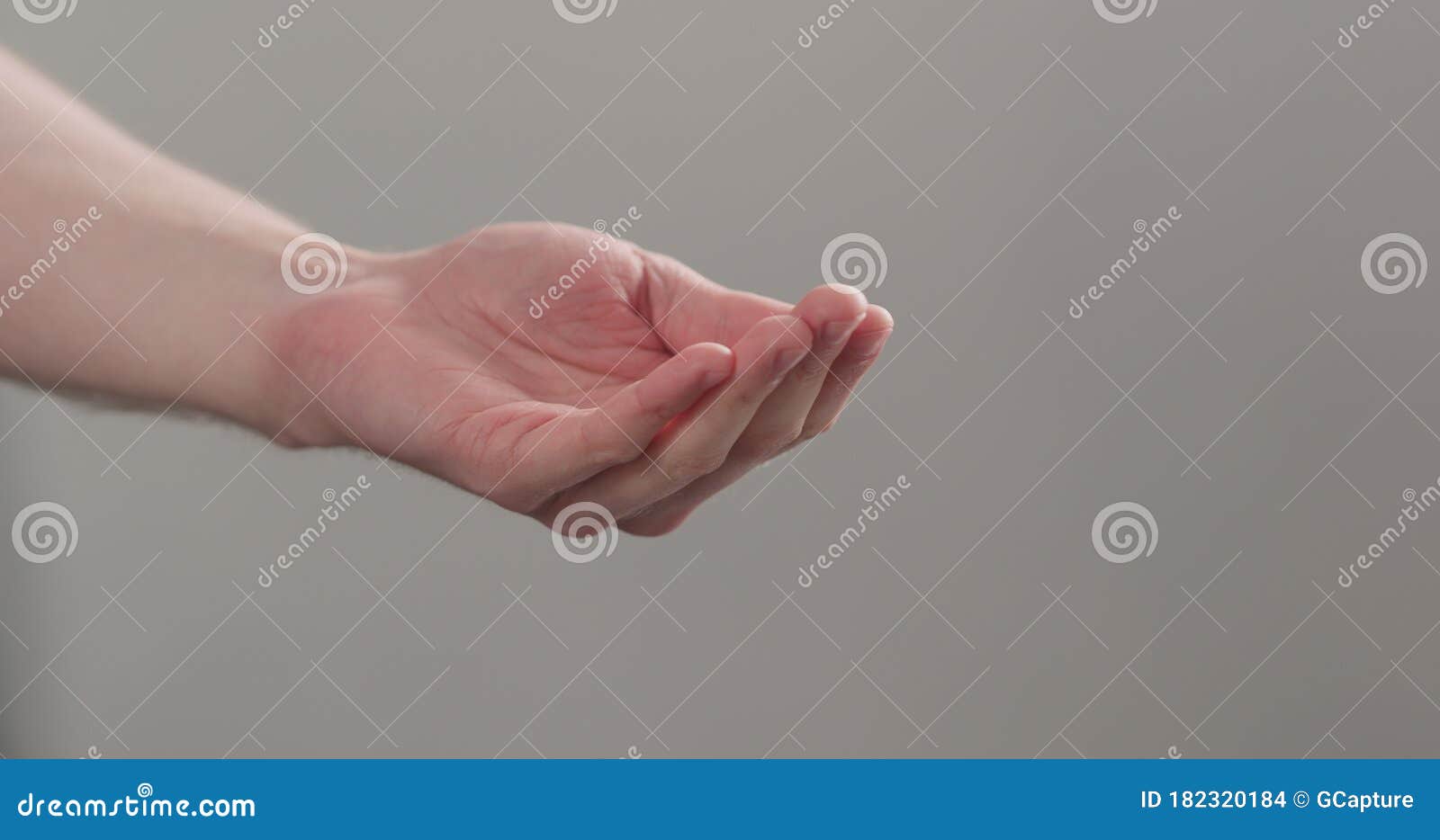 Man Stretches Empty Cupped Hand on Neutral Background Stock Photo ...