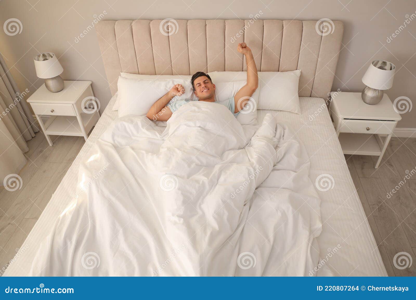 Man Stretching in Bed with White Linens at Home Stock Photo - Image of ...