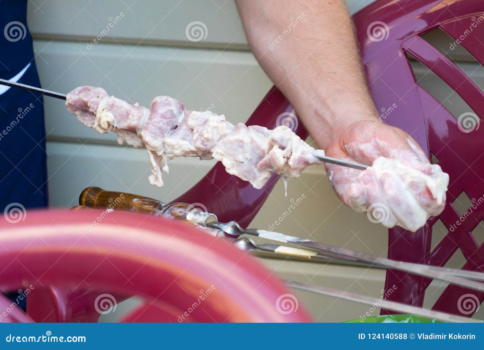 The Man Stringing the Meat for Subsequent Cooking on the Fire. Stock ...