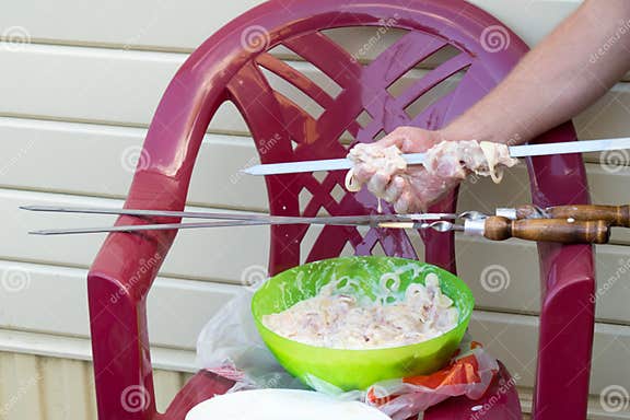 The Man Stringing the Meat for Subsequent Cooking on the Fire. Stock ...