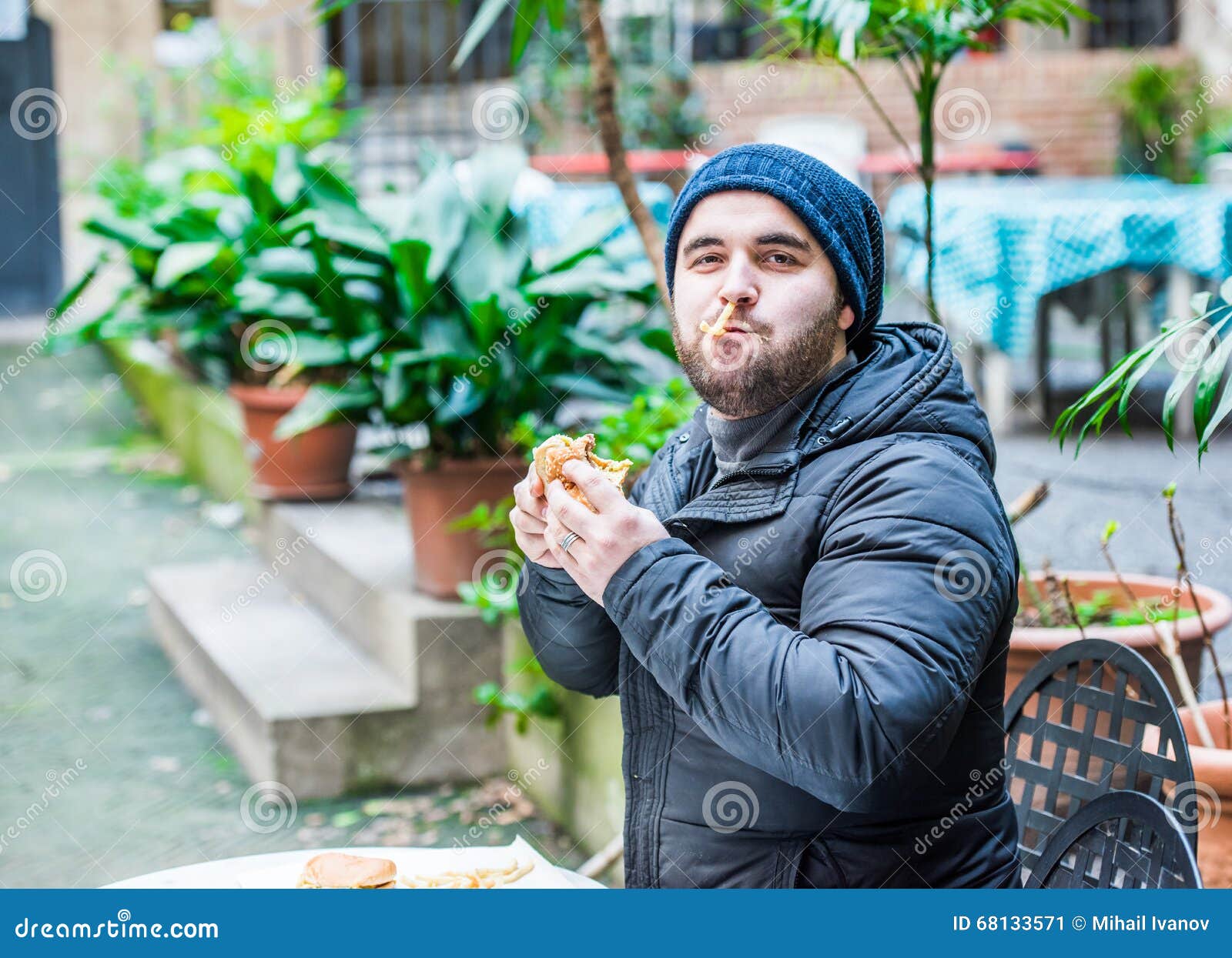 Man Stuffing His Face with a Hamburger and Feeling Nice - Side View ...