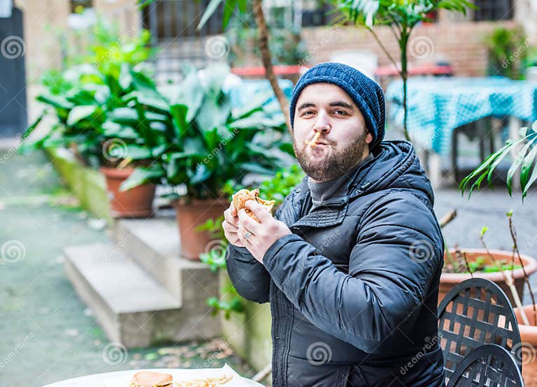 Man Stuffing His Face with a Hamburger and Feeling Nice - Side View ...