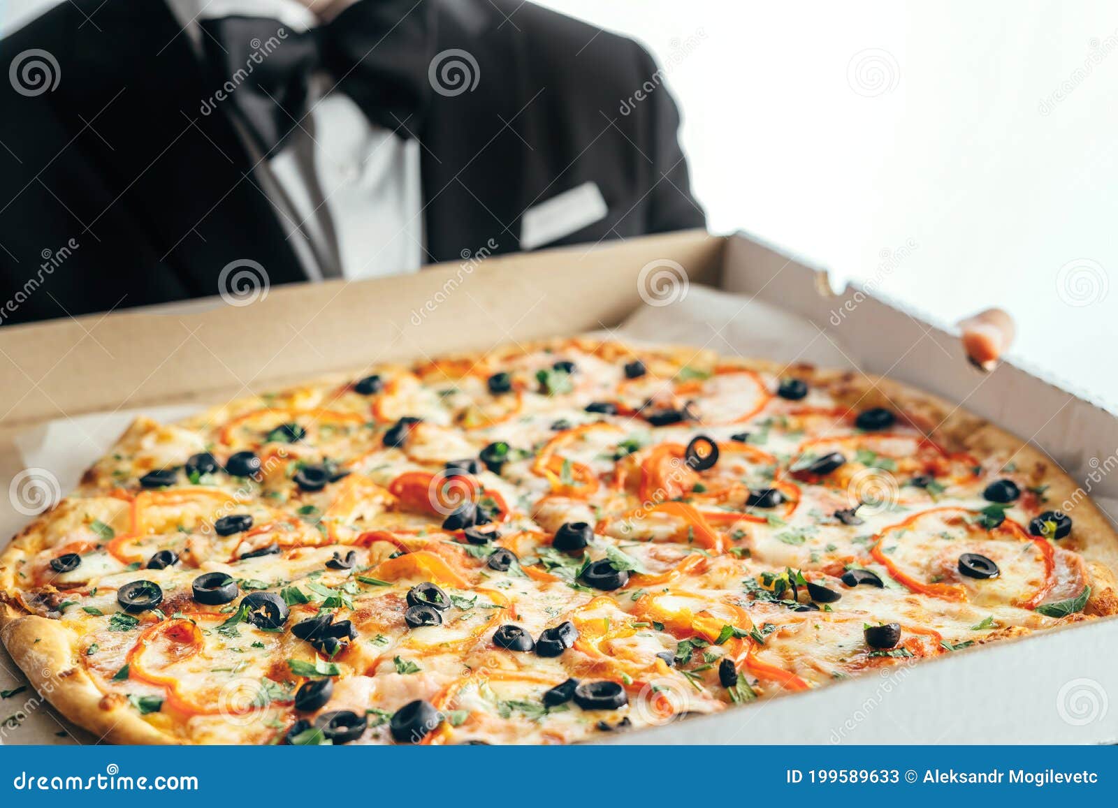 A Man in a Suit and Bow Tie Holds a Box of Pizza in His Hands. Stock ...