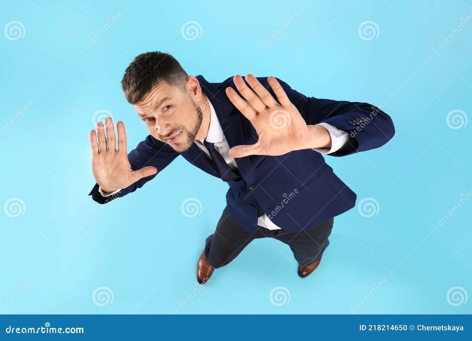 Man in Suit Evading Something on Light Blue Background, Above View ...