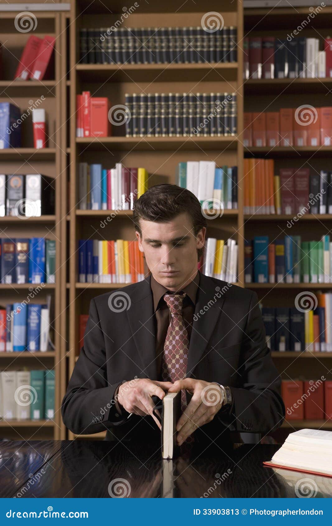 Man in Suit Opening Book at Library Desk Stock Image - Image of library ...