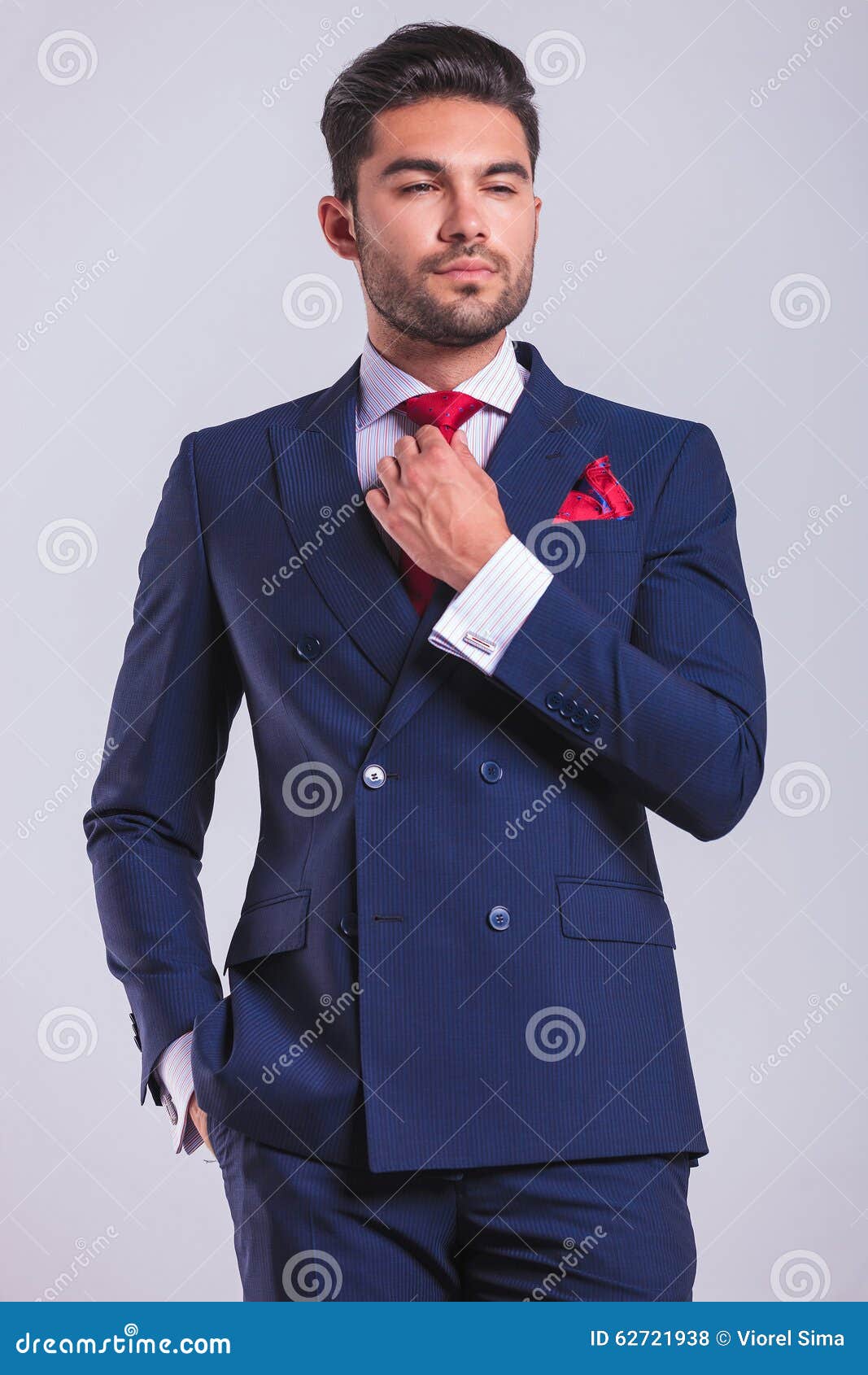 Man in Suit in Studio with Hand in Pocket while Fixing His Tie Stock ...