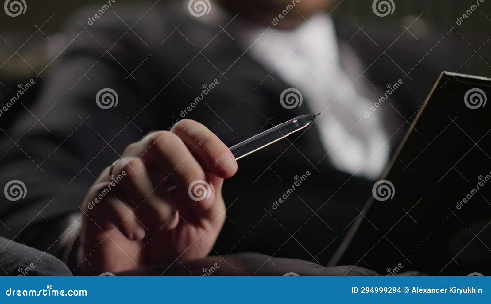 A Man in a Suit is Twirling a Pen in His Hand and Thinking about ...