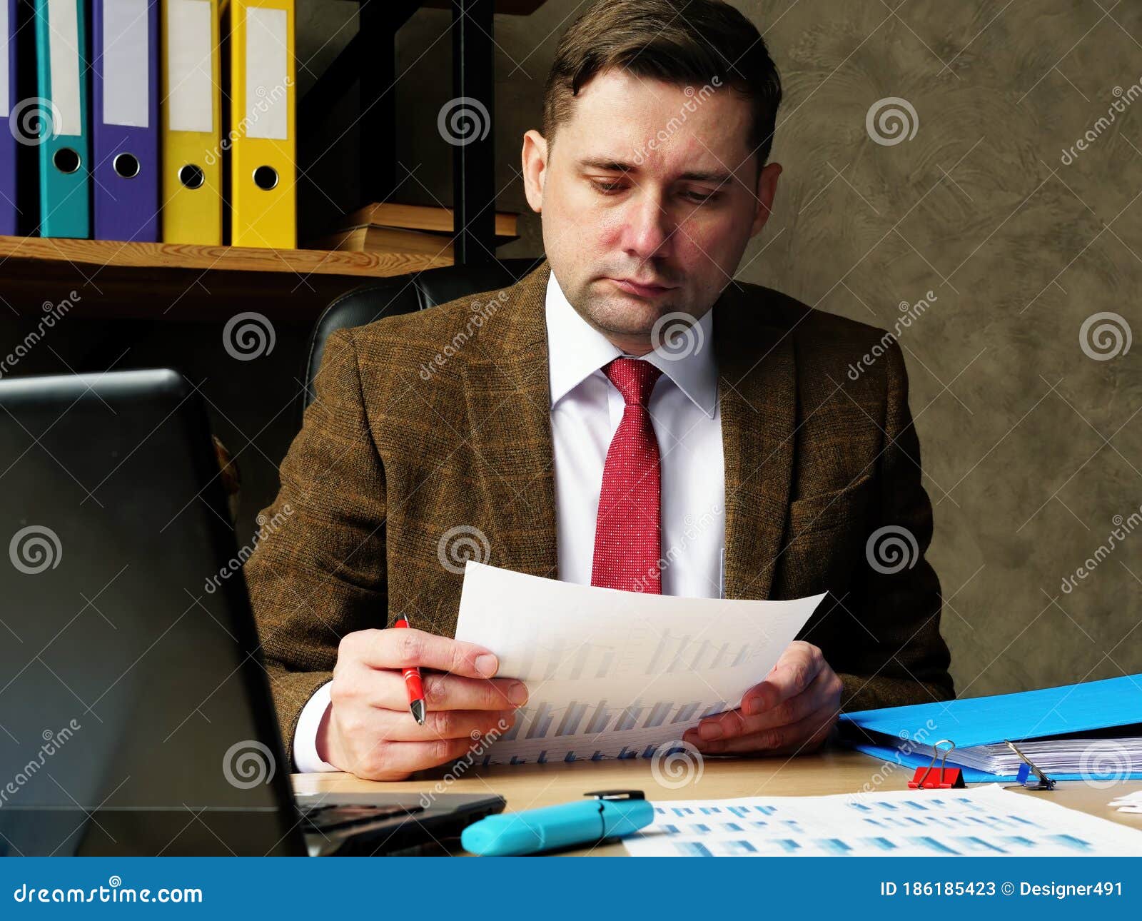 A Man in a Suit Works with Papers and Checks Data with Graphs. Office ...