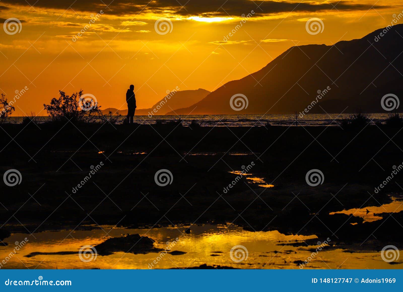 Man at sunset stock image. Image of water, person, landscape - 148127747