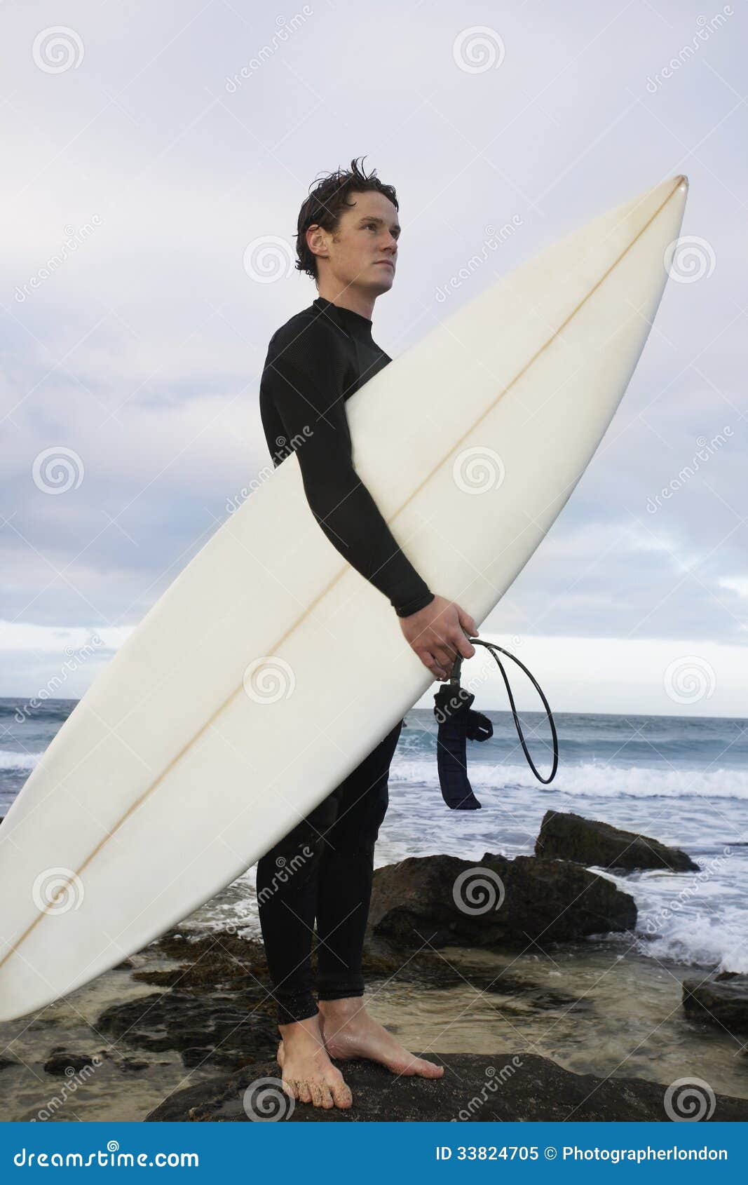 Man with Surfboard Standing on Rock at Beach Stock Image - Image of ...